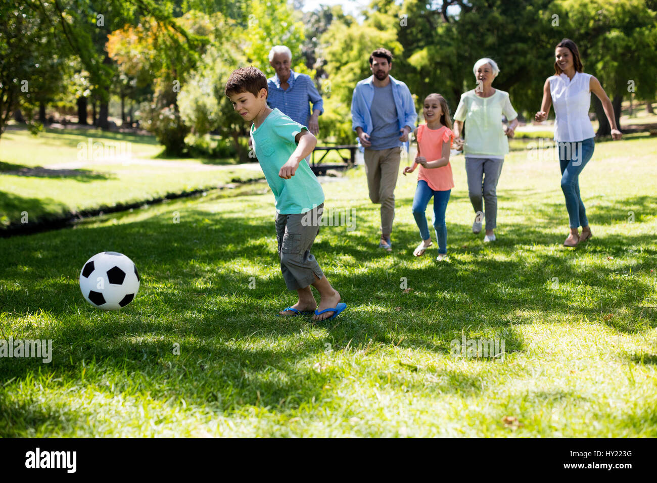 Cheerful multi generation family playing football in park Stock Photo ...