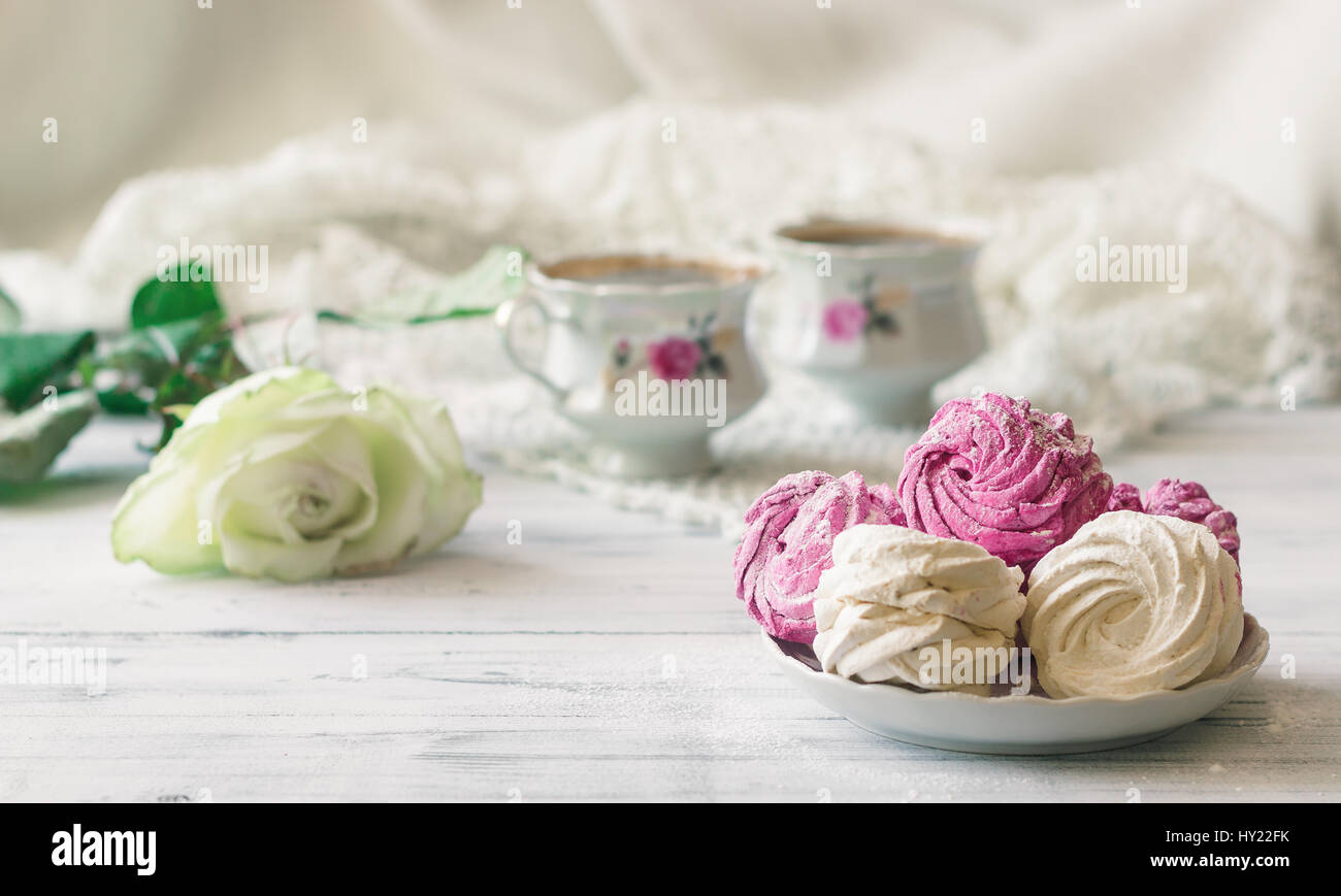 Zephyr (Russian marshmallow) on light wooden table with two coffee cups ...