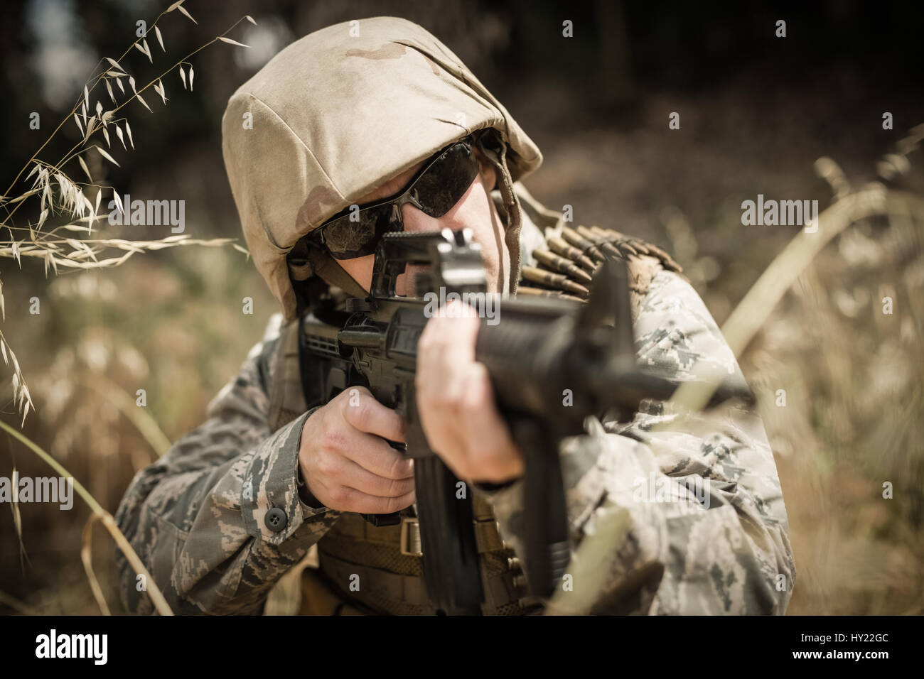 Military soldier hiding in grass while guarding with a rifle in boot ...
