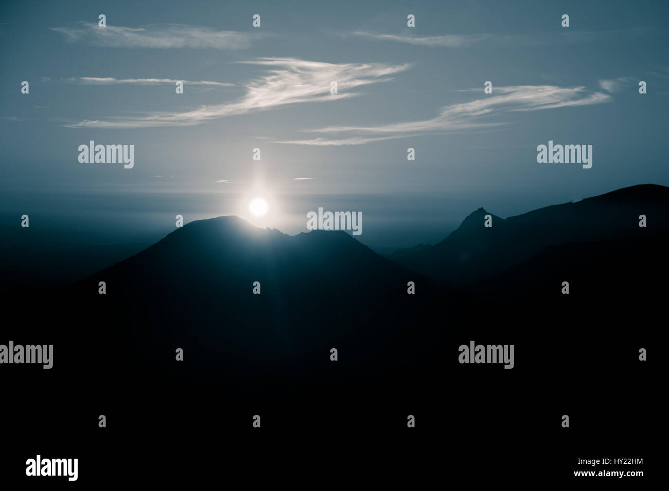 A beautiful, abstract monochrome mountain landscape with sun in blue ...