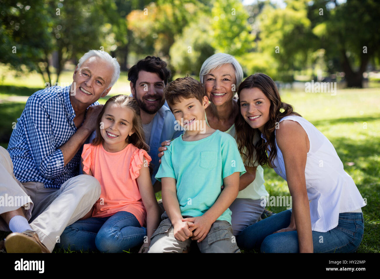 Portrait of multi generation family sitting in park Stock Photo - Alamy