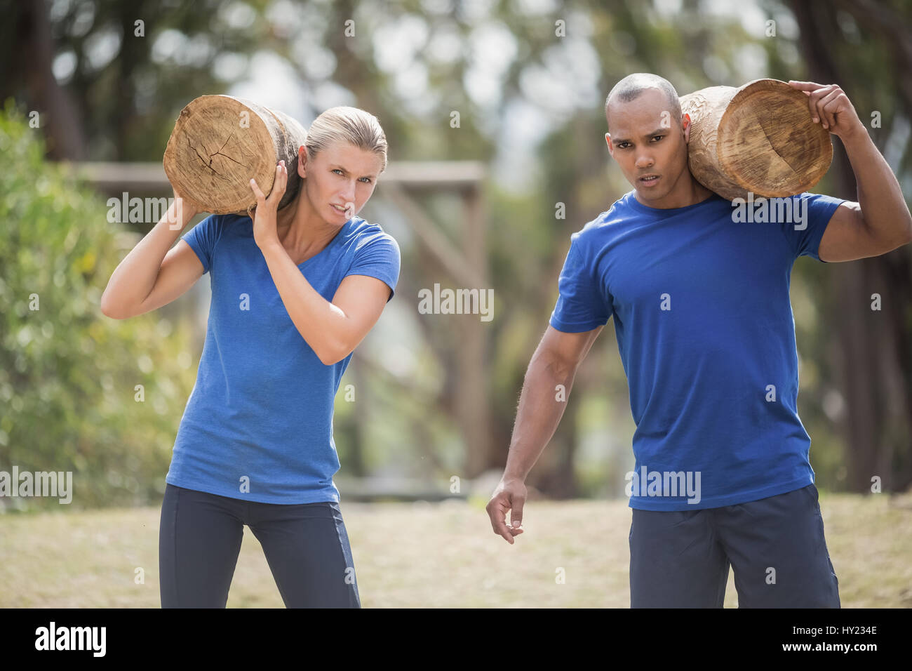 People carrying heavy wooden logs during obstacle course in boot camp ...