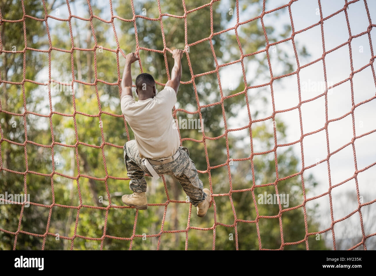Military soldier climbing net during obstacle course in boot camp Stock ...