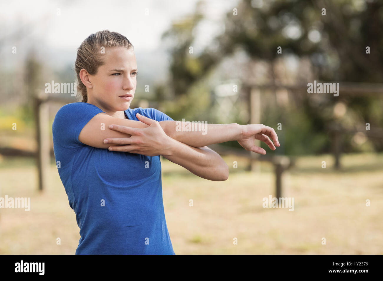 Fit woman performing stretching exercising during obstacle course in ...