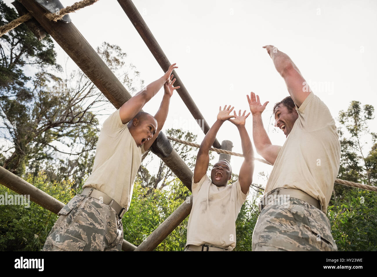 Military soldiers with hands stacked during obstacle training in boot ...