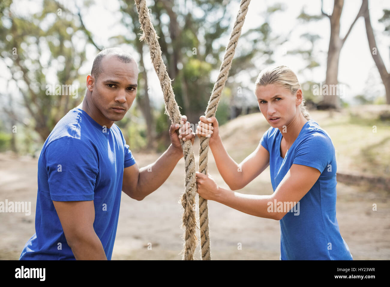 Portrait of fit people holding rope during boot camp training Stock ...