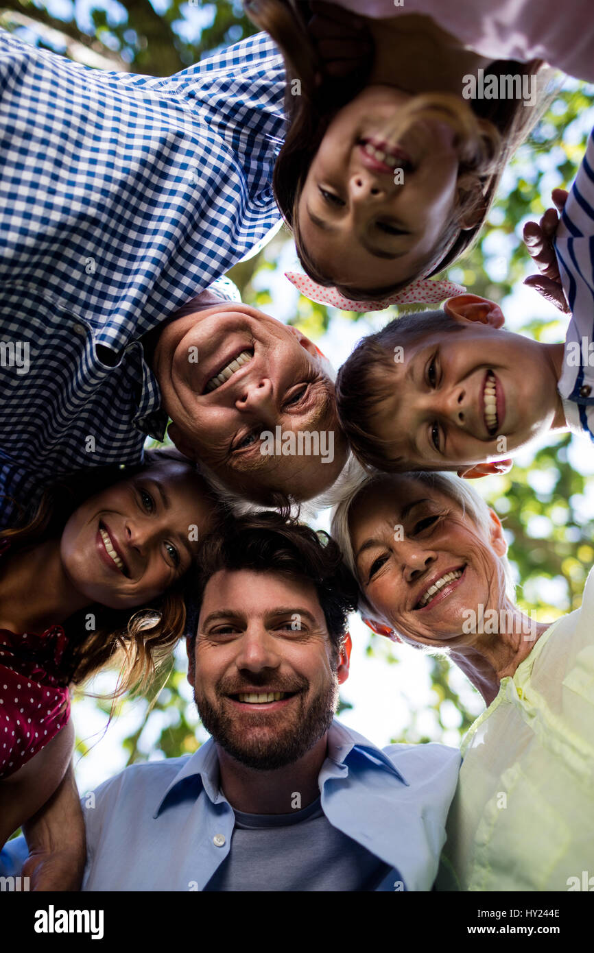 Portrait of multi generation family forming a huddle in park Stock ...