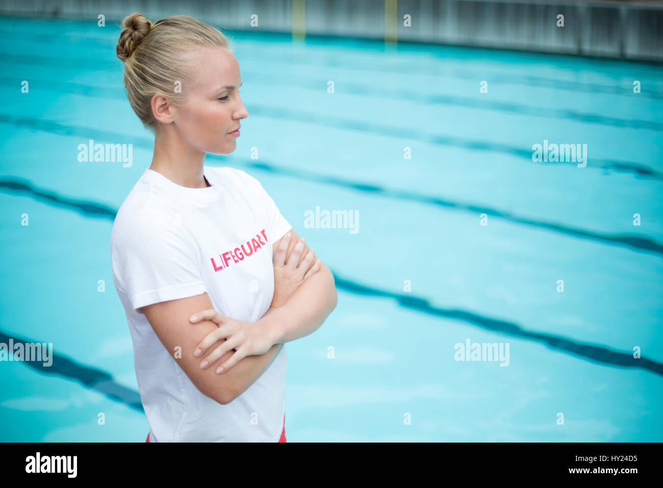 Confident female lifeguard standing at poolside Stock Photo - Alamy
