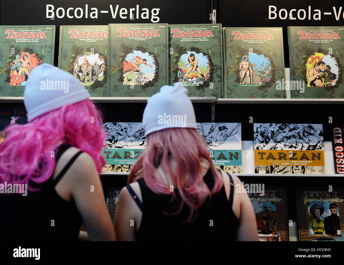 Leipzig, Germany. 24th Mar, 2017. Cosplayers look at new comics and ...