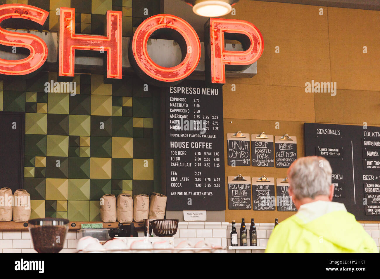 Cafe menu on wall with customer at counter in modern upscale cafe Stock ...