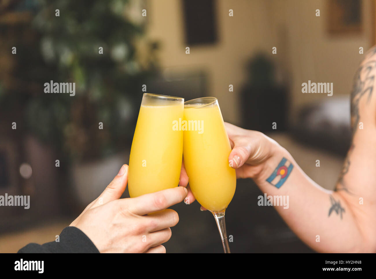 Two people tapping their beverages together for a "cheers" moment. Two ...