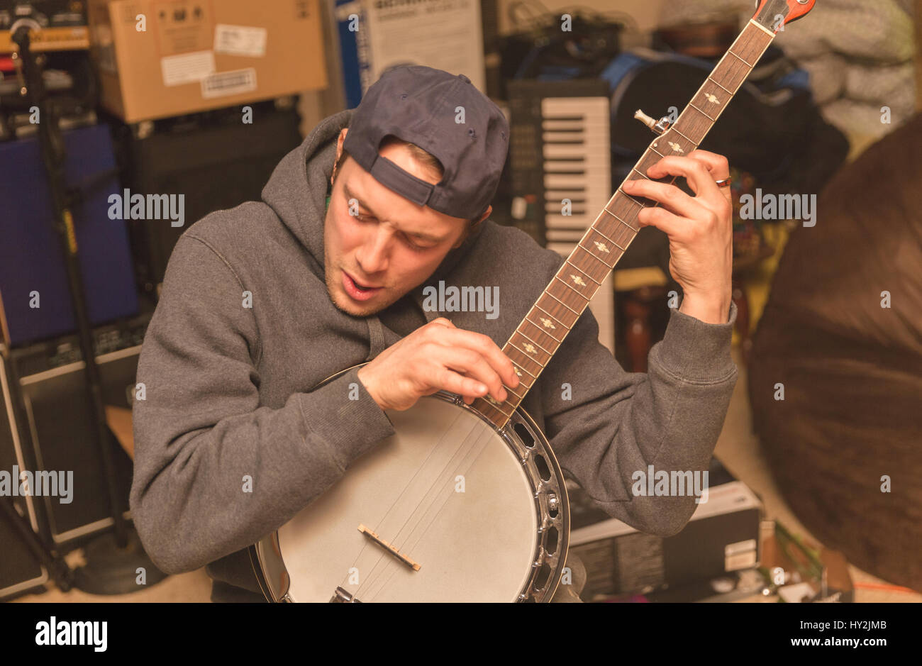 Man playing banjo in a recording space or jam room Stock Photo - Alamy