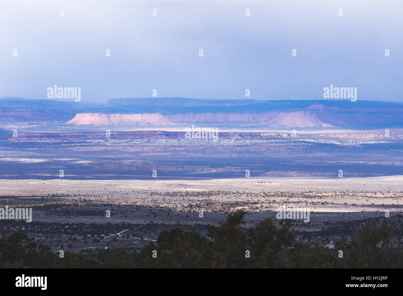 Desert landscape with clouds over mesas. Winter day with snow on ground ...