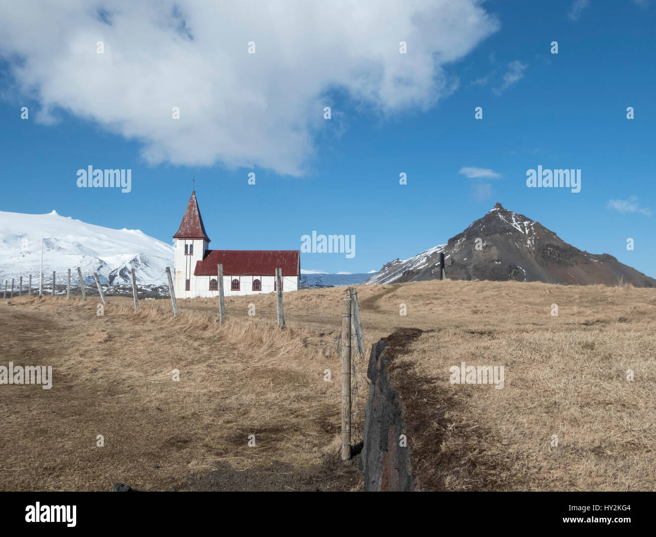 The church in Hellnar is seen in front of a snow capped mountain in the ...