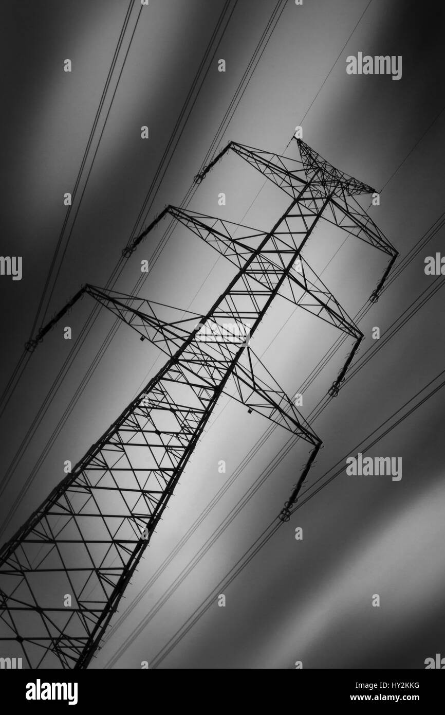 Tall power line tower, blurry clouds. Black and white dynamic slanting ...