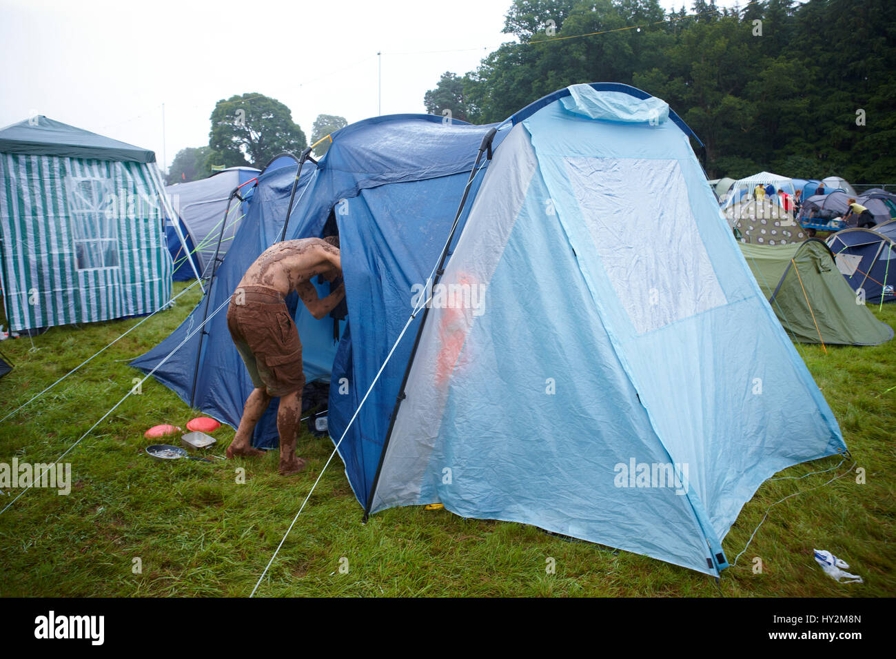 Muddy people going in a blue tent, Green Man Festival, Wales Stock ...