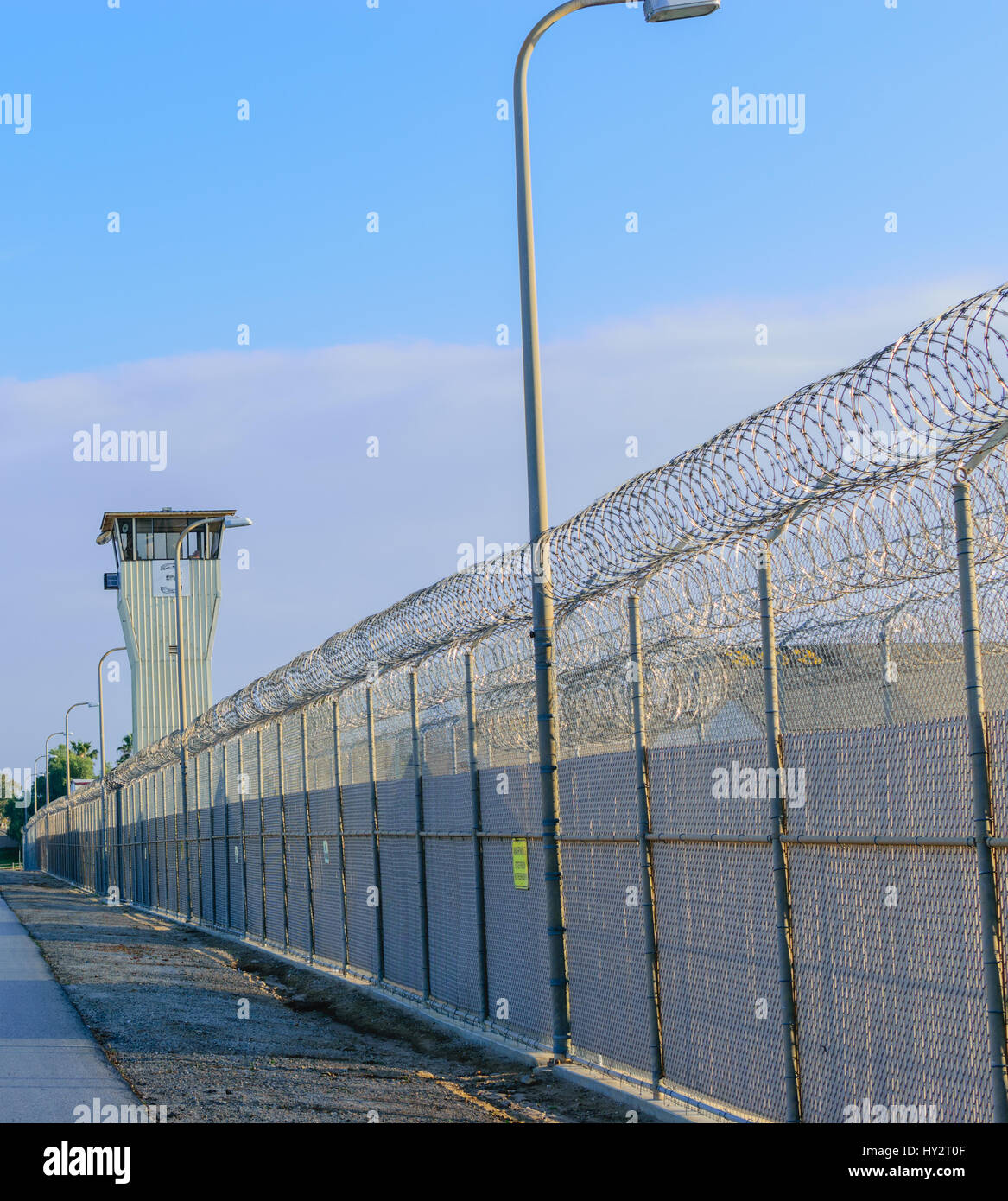 Prison fence line facing north with guard tower Stock Photo - Alamy
