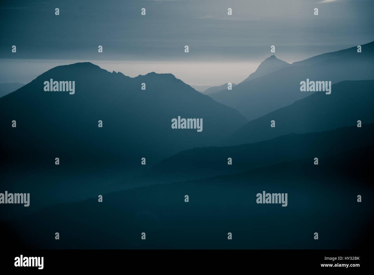 A beautiful, abstract monochrome mountain landscape in blue tonality ...
