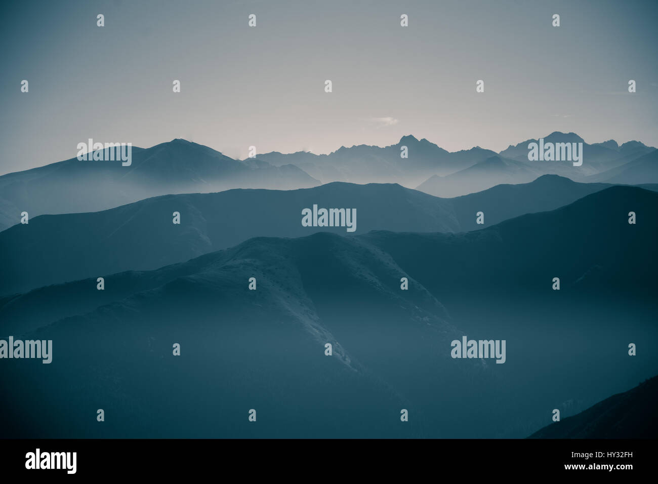 A beautiful, abstract monochrome mountain landscape in blue tonality ...