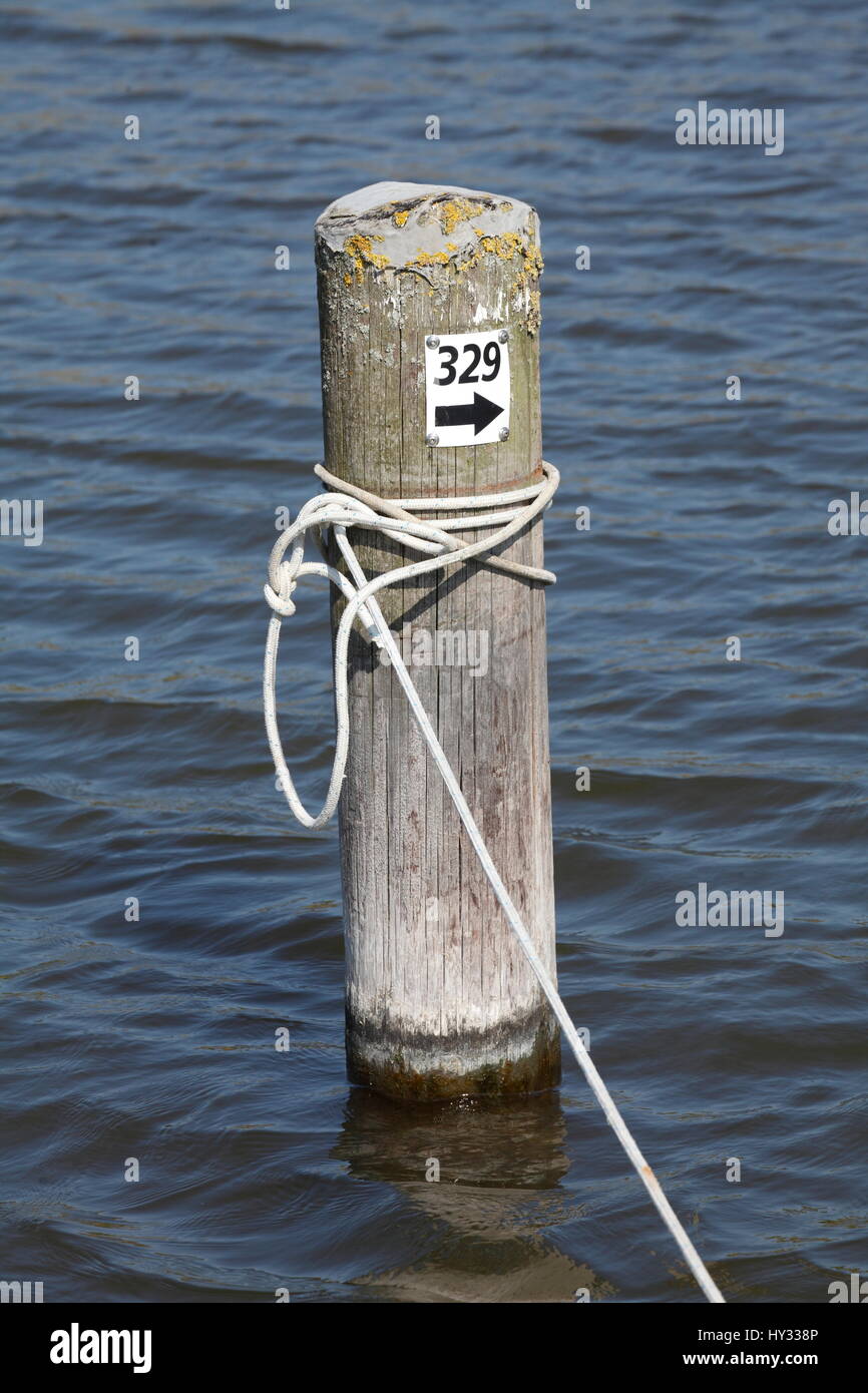 wooden peg with rope in a harbour Stock Photo - Alamy