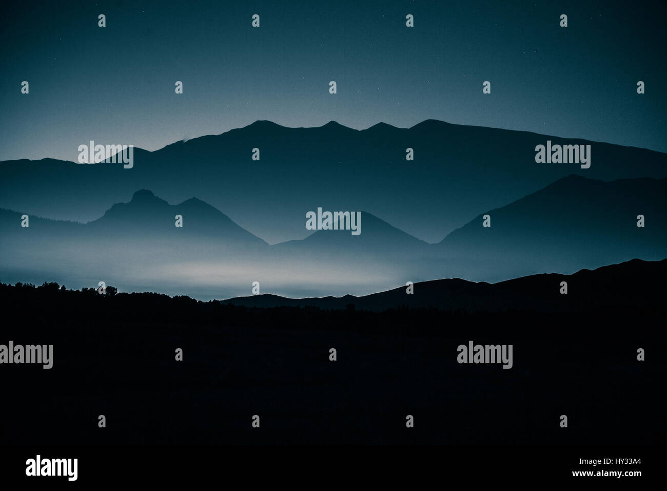 A beautiful, abstract monochrome mountain landscape in blue tonality ...