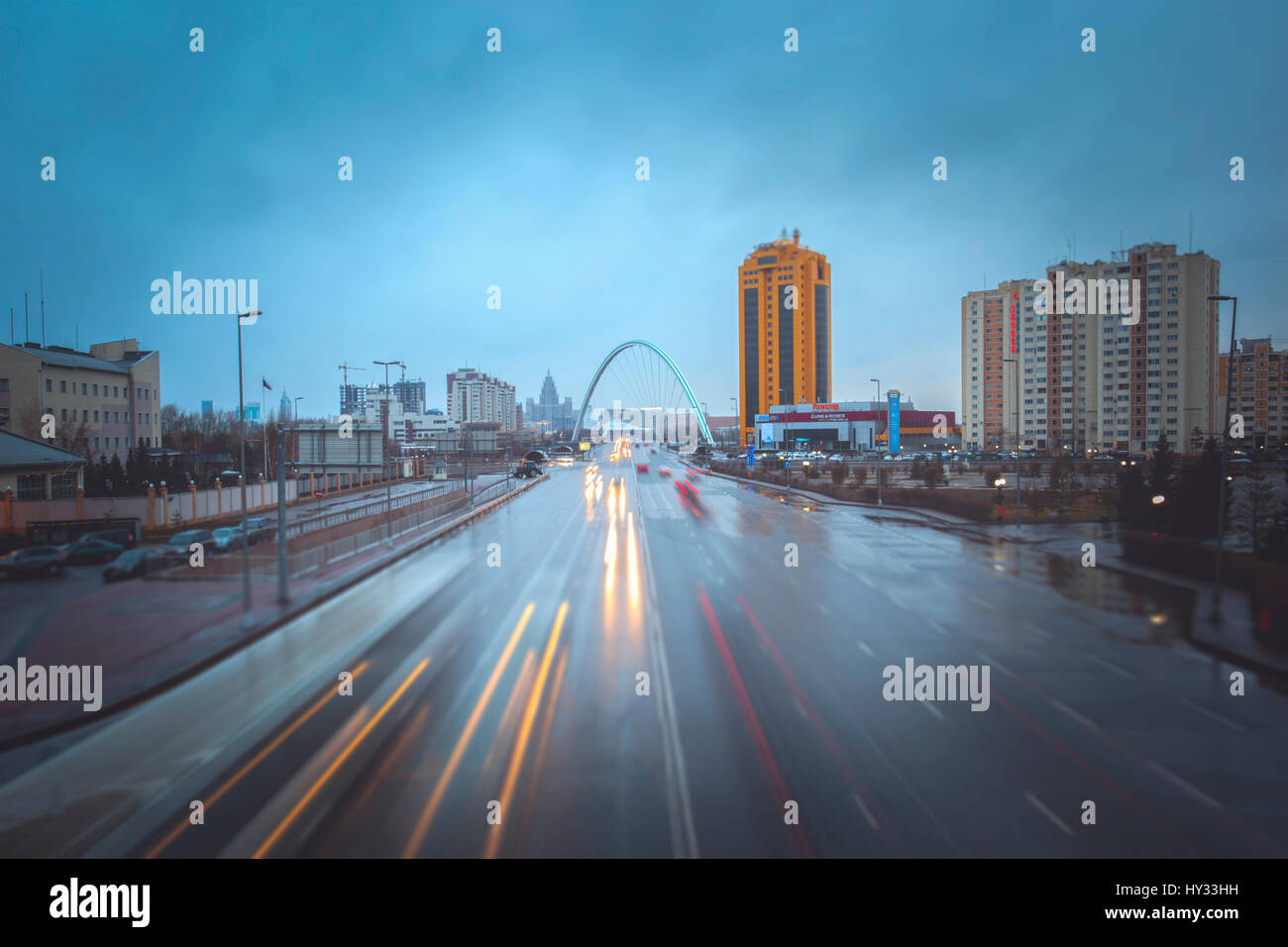 Rainy weather in Astana, on the road going car. Buildings and bridge in ...