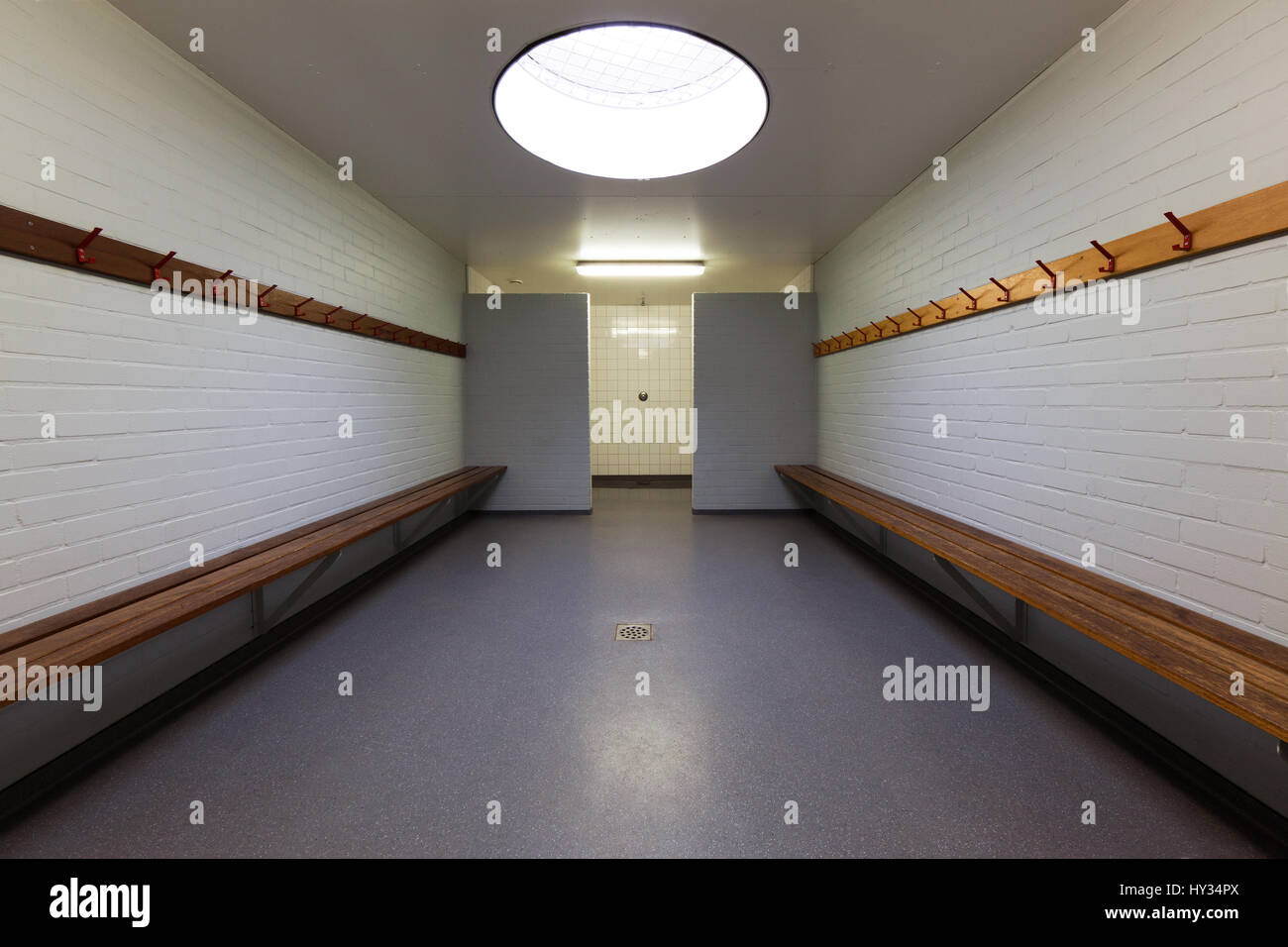 An empty changing room with a shower in the back Stock Photo - Alamy
