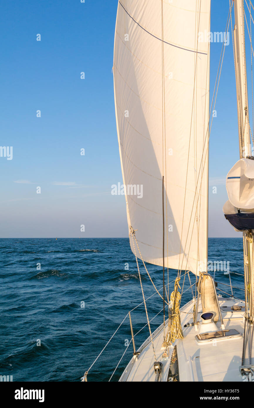 Front of sailing boat with foresail cruising on calm and sunny ...