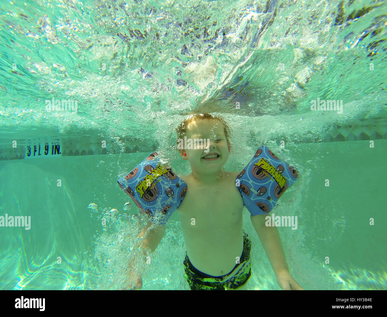 underwater in pool looking up boy jumps in Stock Photo - Alamy