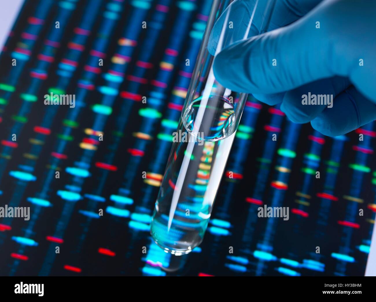 A test tube with a sample being held in front of DNA (deoxyribonucleic ...
