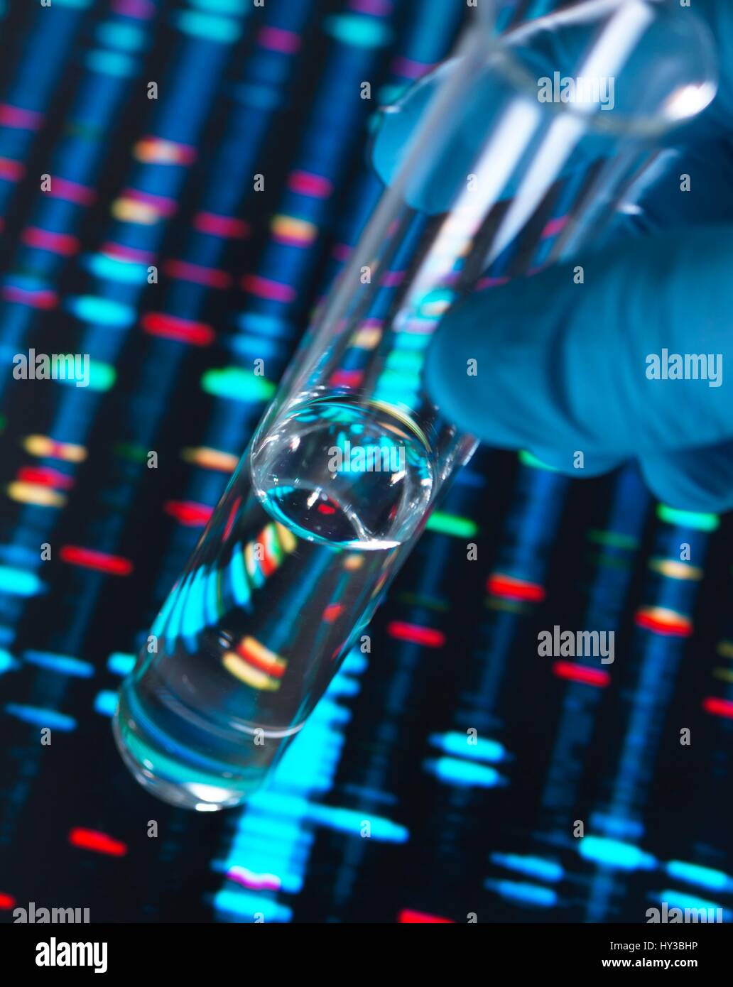 A test tube with a sample being held in front of DNA (deoxyribonucleic ...