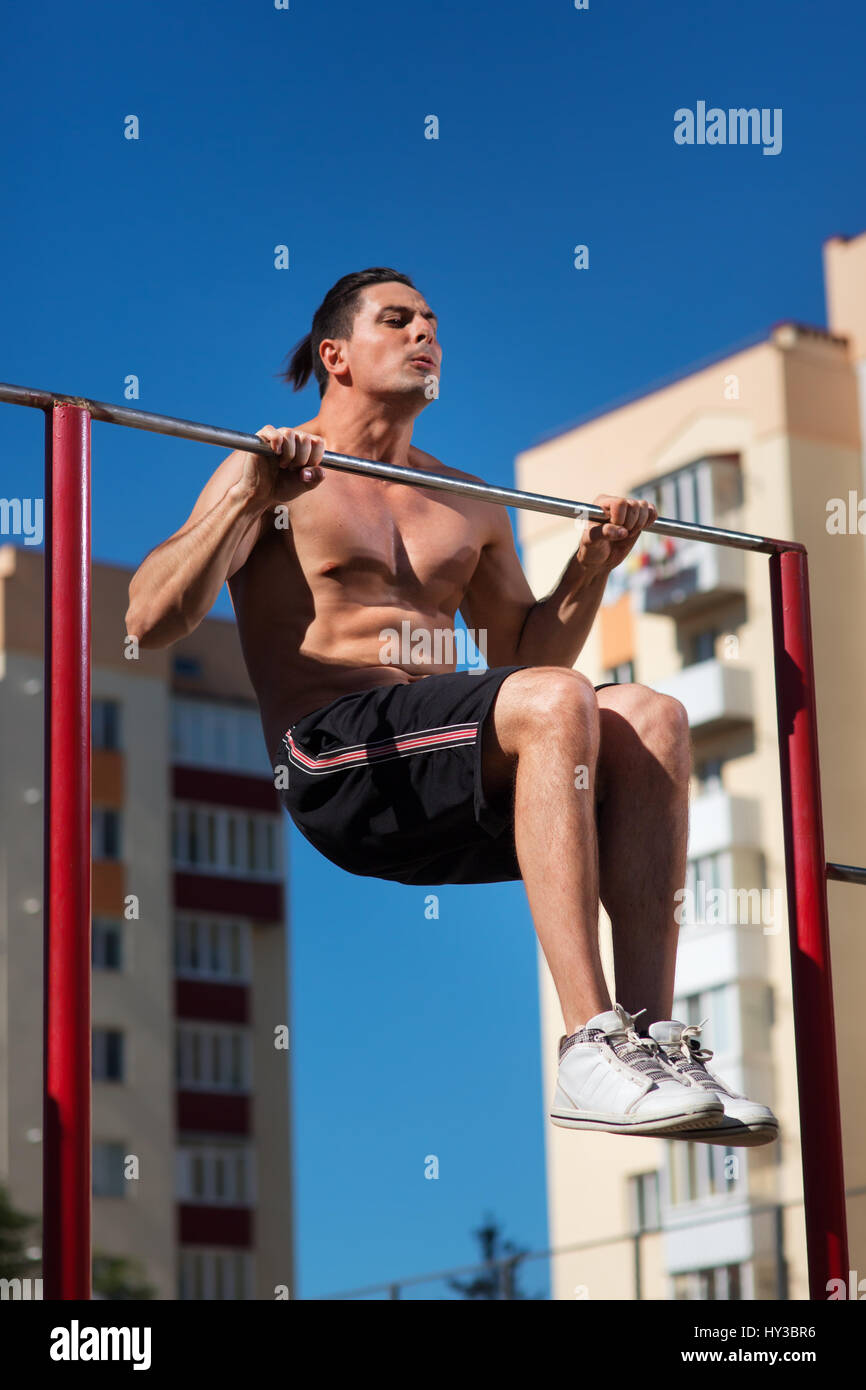 Workout, sportsman pull ups the horizontal bar with big effort Stock ...