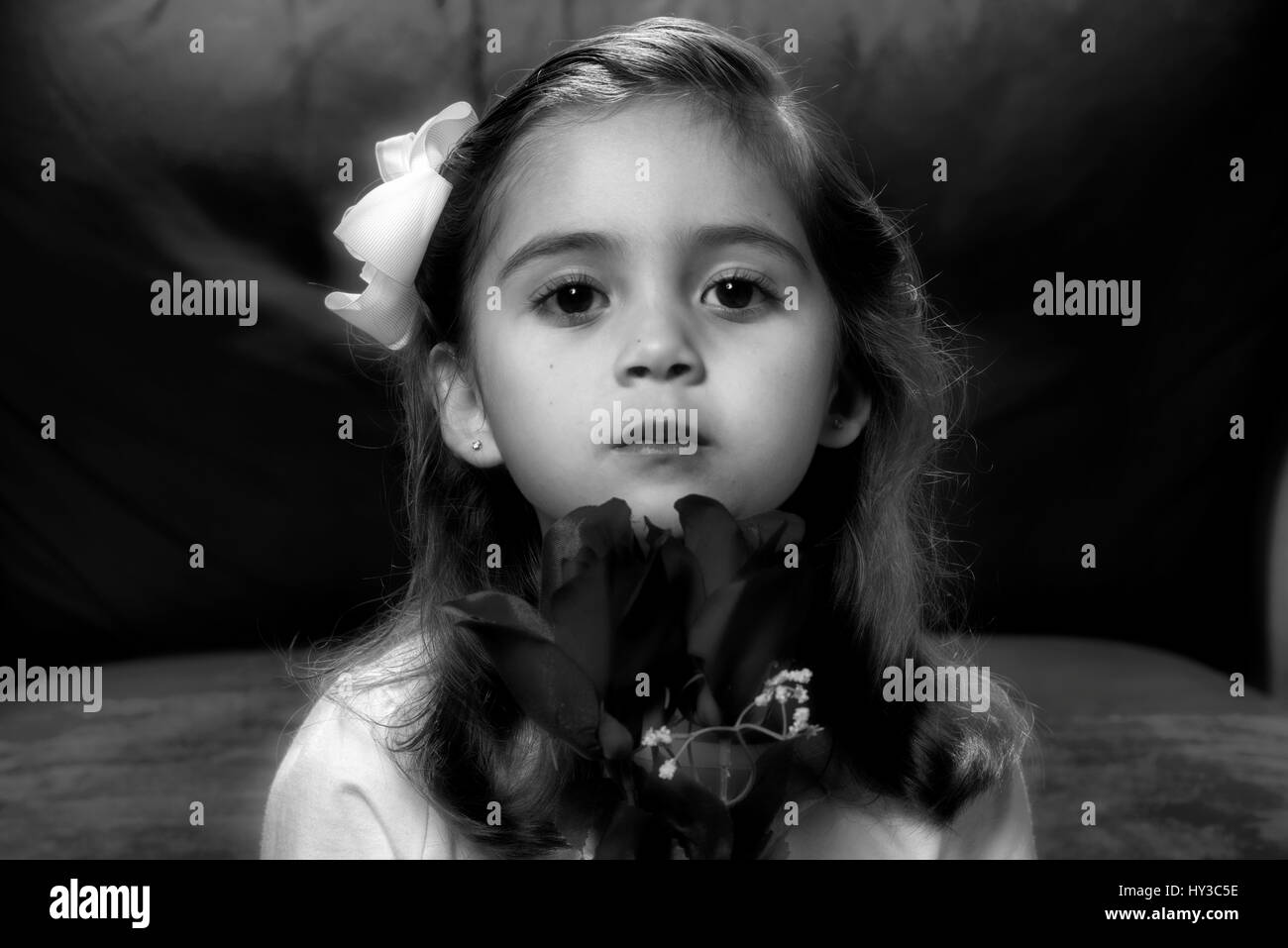 little girl looking over red roses in black & white Stock Photo - Alamy