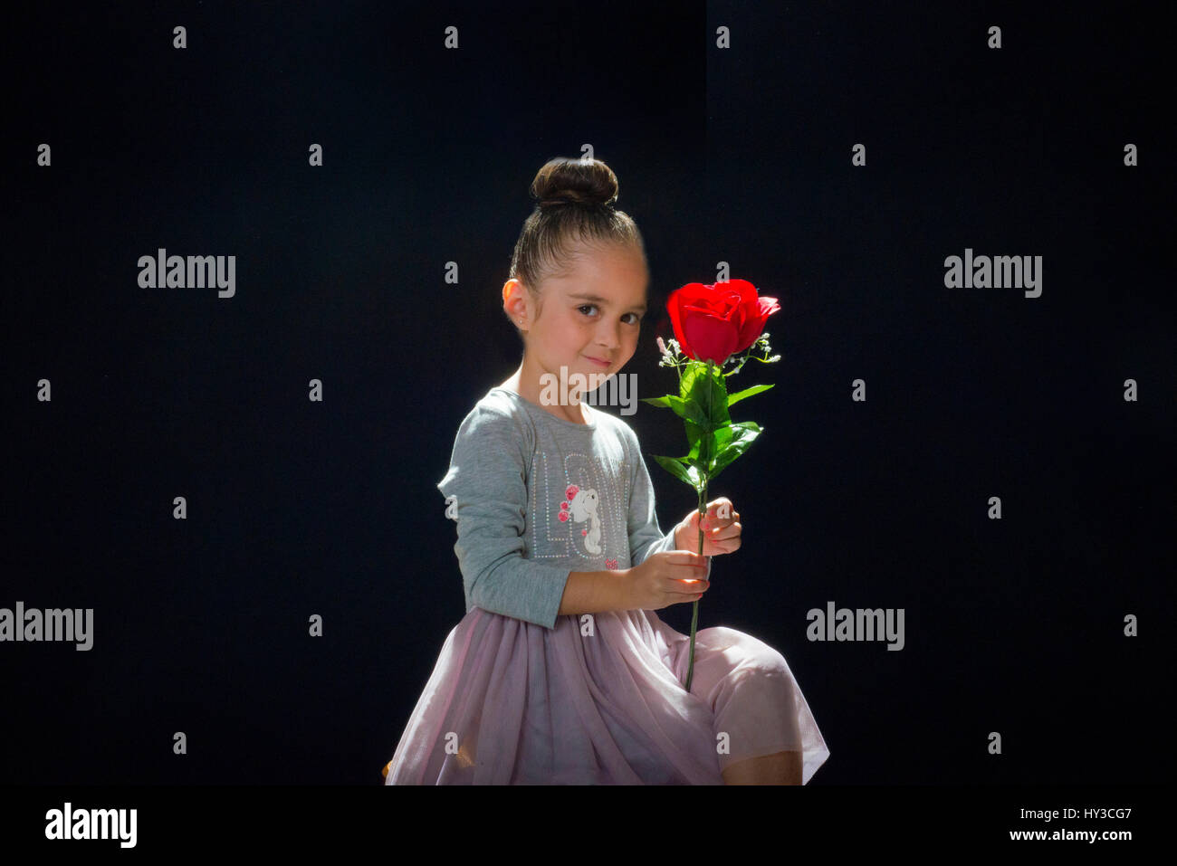 young girl holding roses in studio setting Stock Photo - Alamy