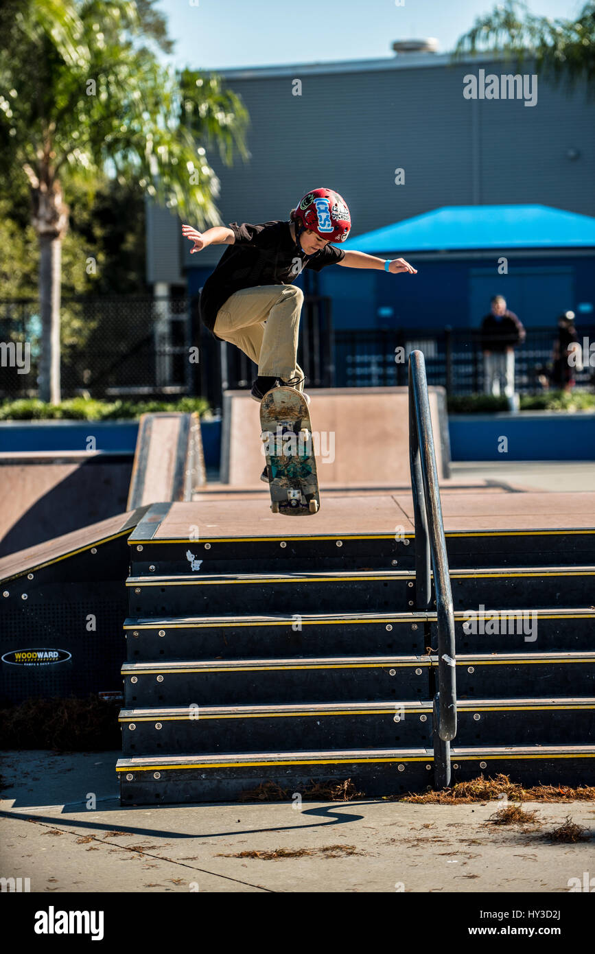 young boy on skate board jumping steps Stock Photo - Alamy