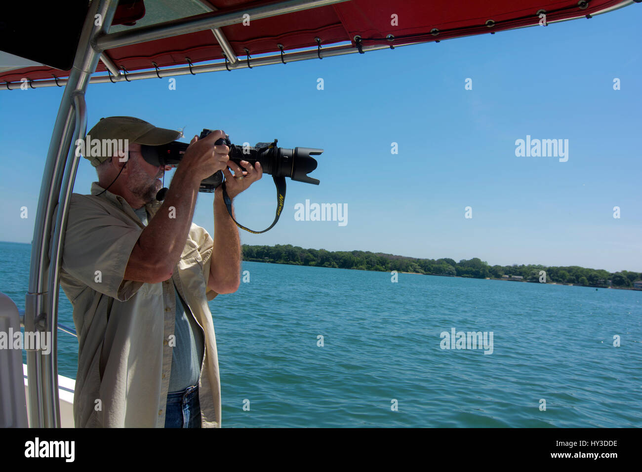professional photographer shooting with long lens on boat Stock Photo ...