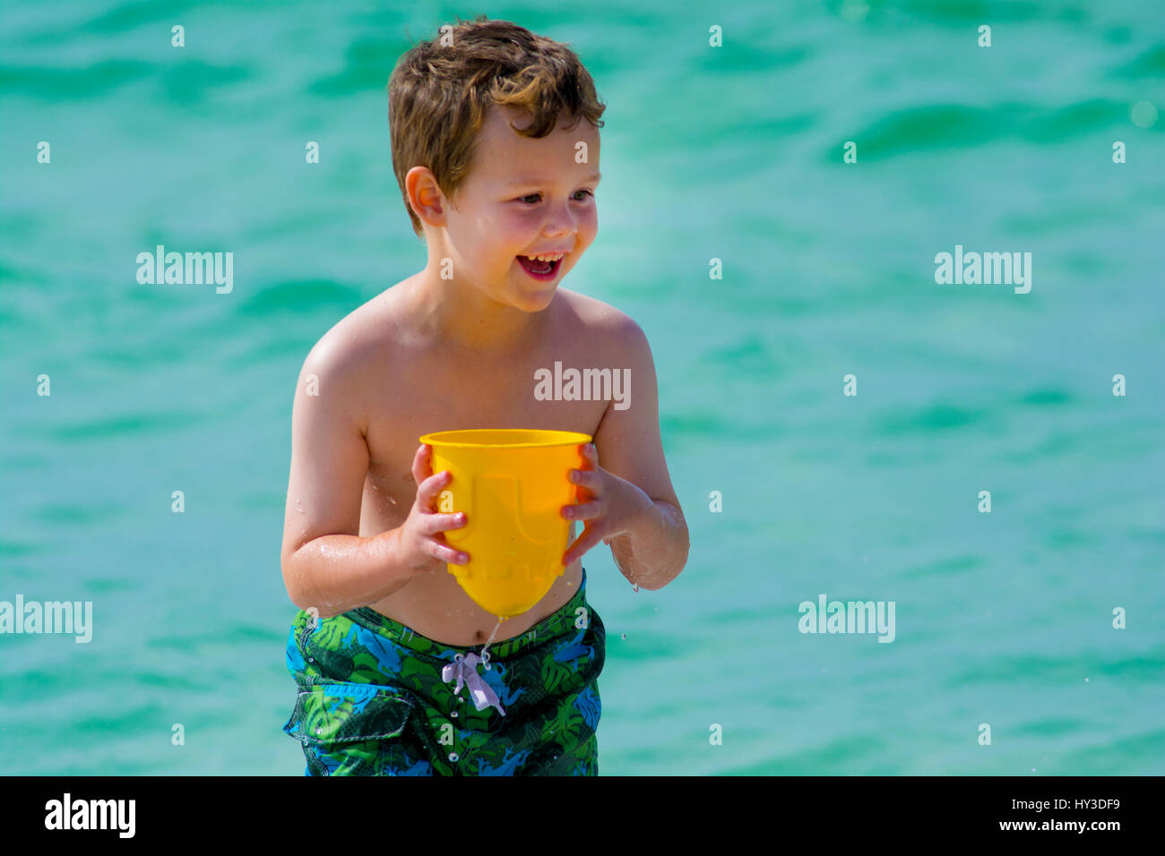 young boy at the beach playing with bucket Stock Photo - Alamy