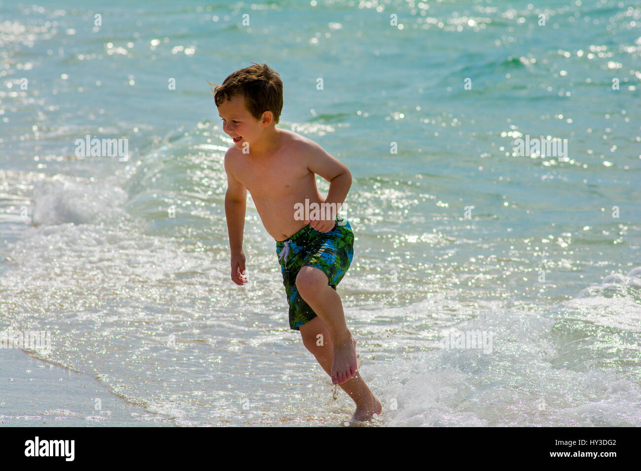 young boy at the beach running having fun Stock Photo - Alamy