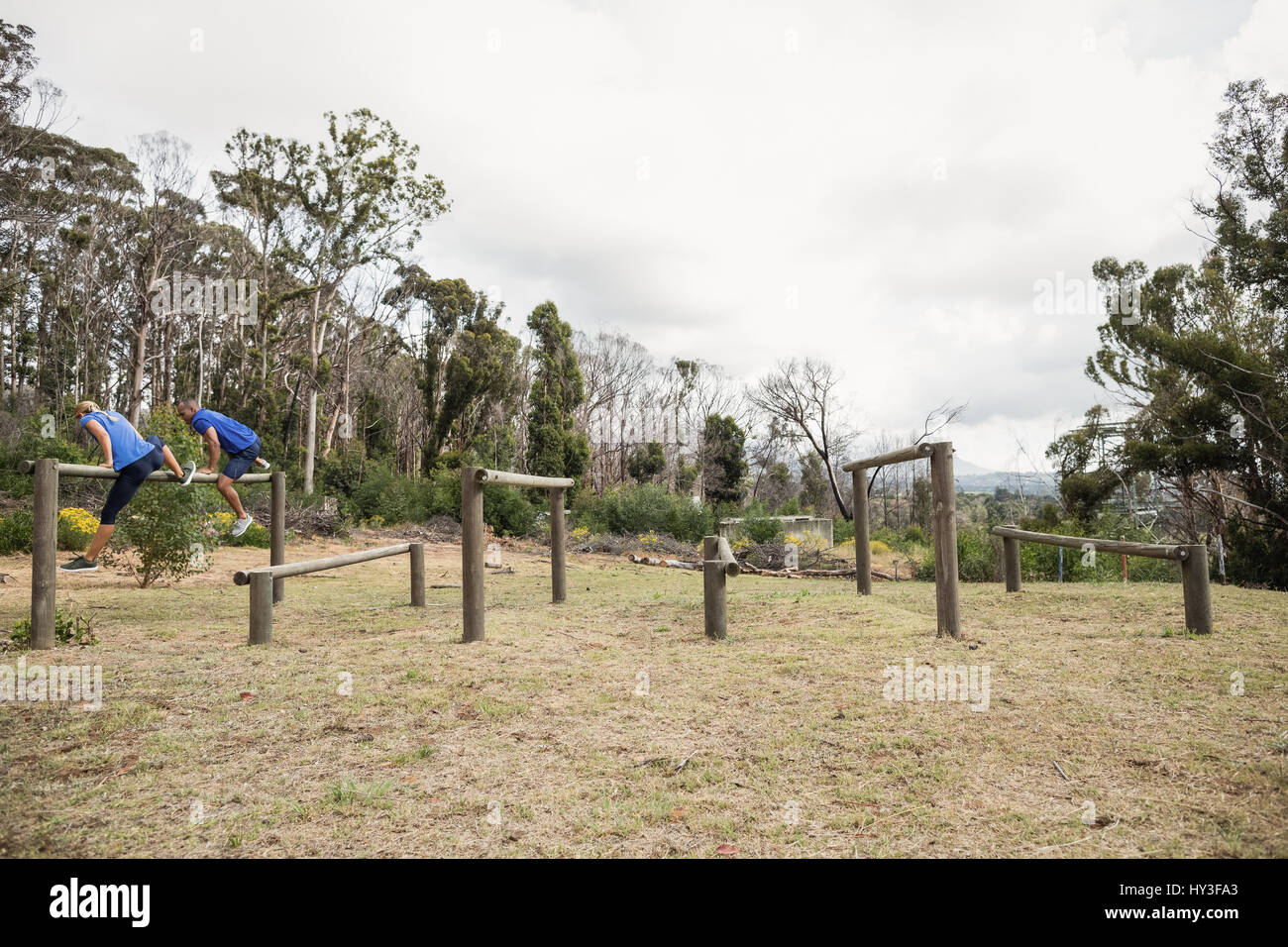 People jumping over the hurdles during obstacle course in boot camp ...