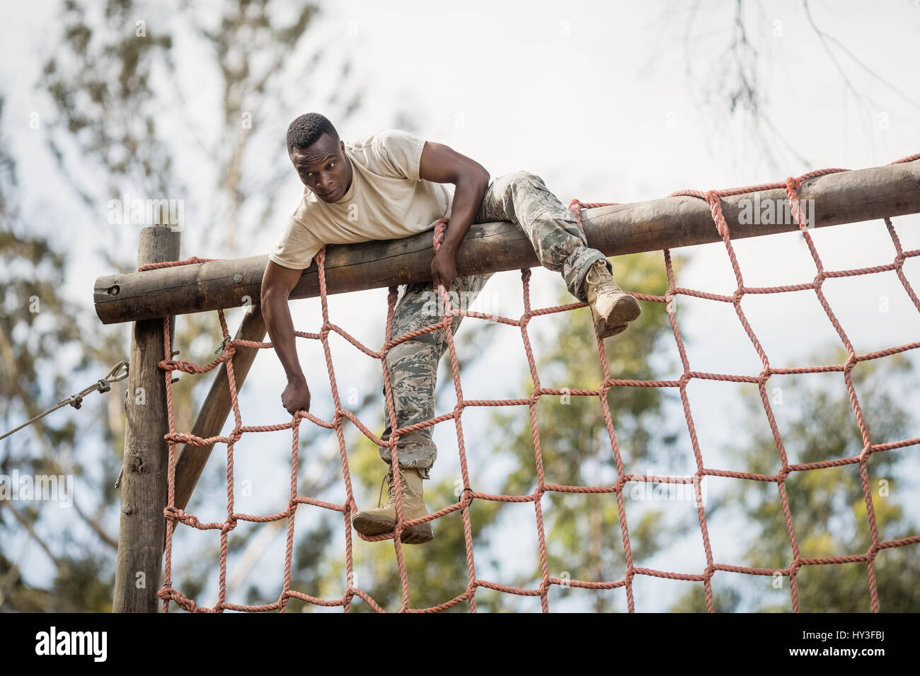 Military soldier climbing net during obstacle course in boot camp Stock ...