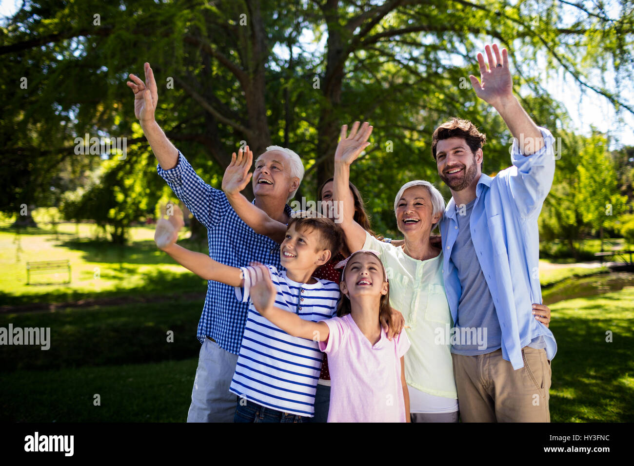Happy multi generation family waving hand in air at the park Stock ...