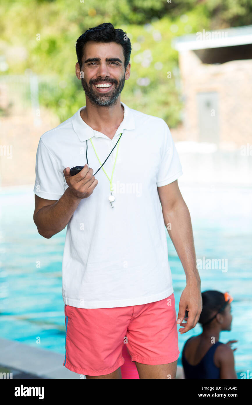Portrait of male instructor standing at poolside Stock Photo - Alamy