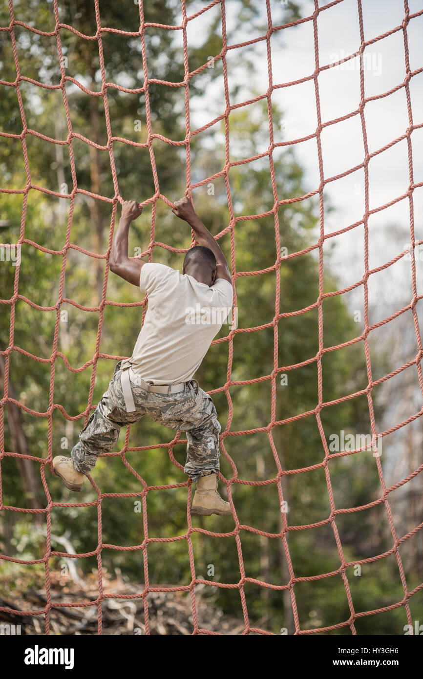 Military soldier climbing net during obstacle course in boot camp Stock ...