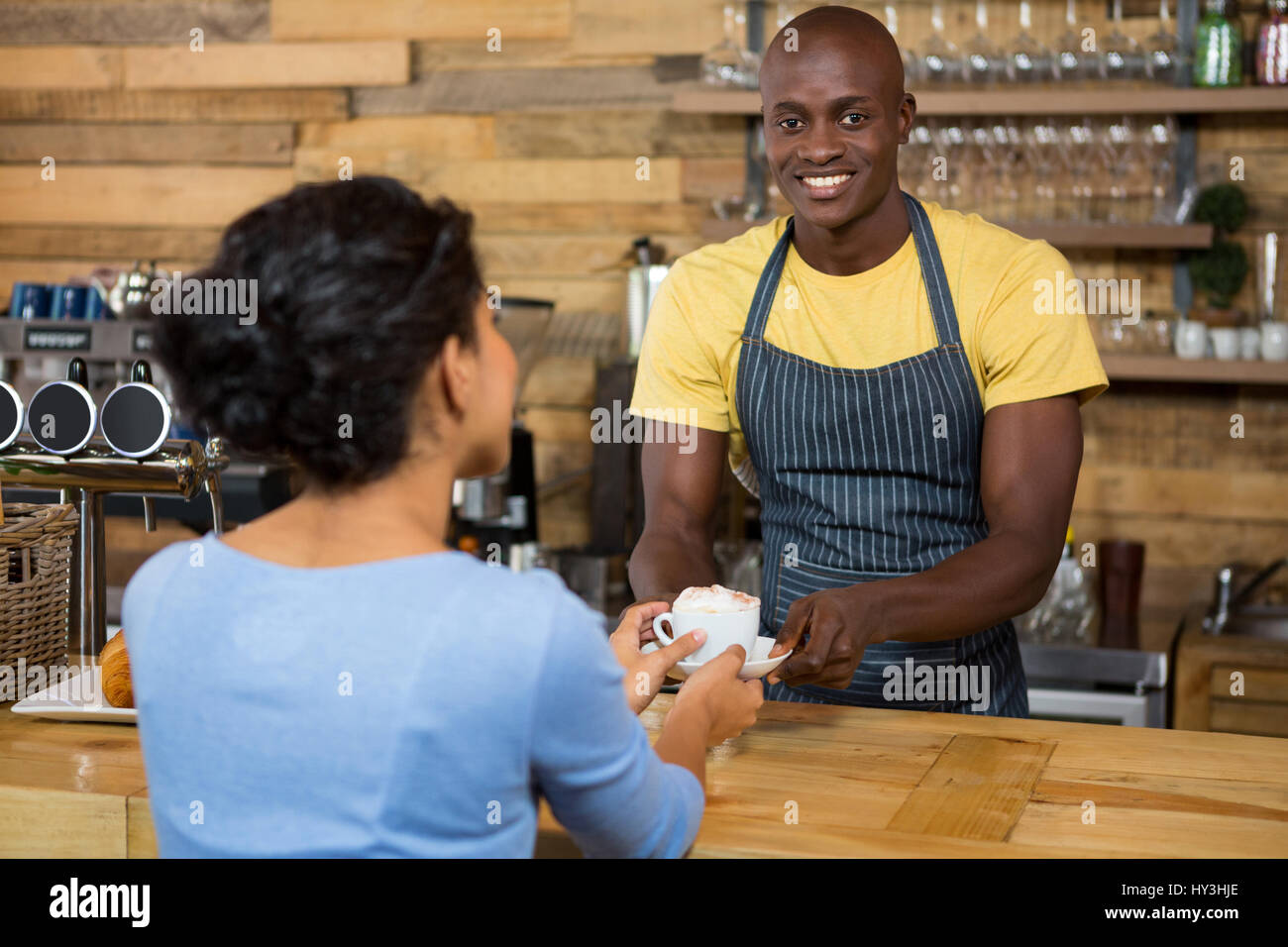 Portrait of happy male barista serving coffee to customer in coffee ...
