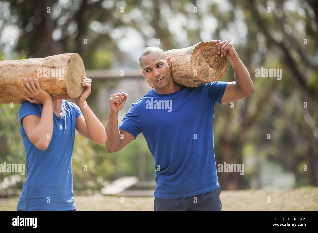 People carrying heavy wooden logs during obstacle course in boot camp ...