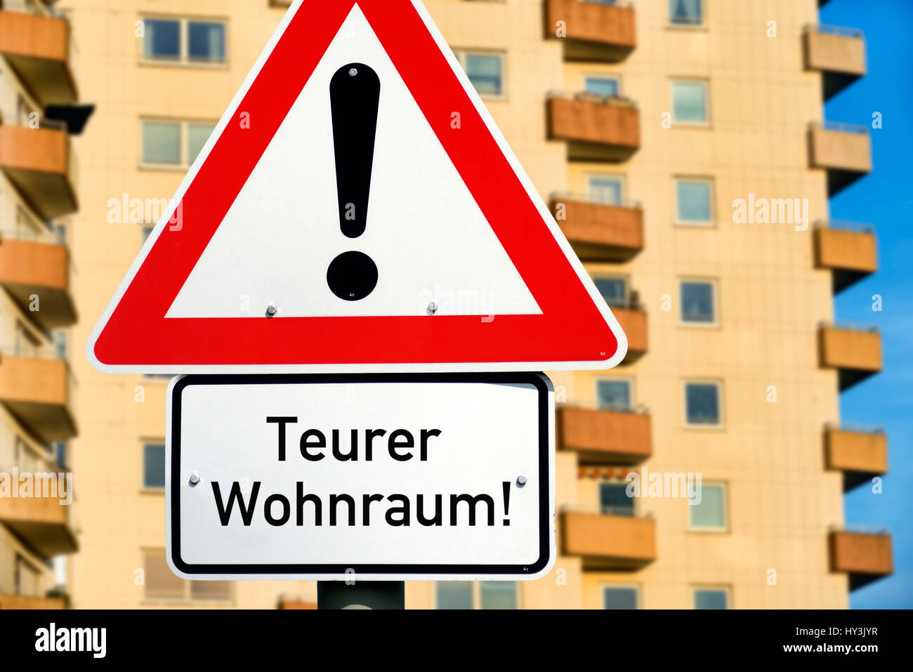 Road sign with label expensive living space before a high rise ...