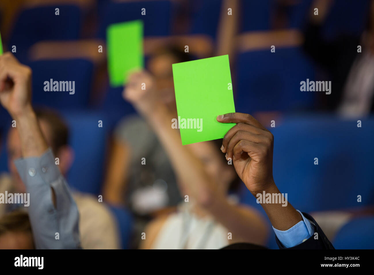 Business executives show their approval by raising hands at conference ...