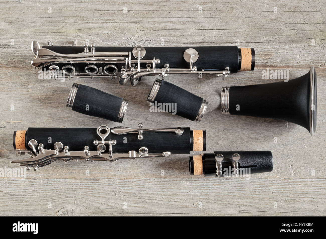 Top view of a black clarinet dismantled in four parts on a gray ...