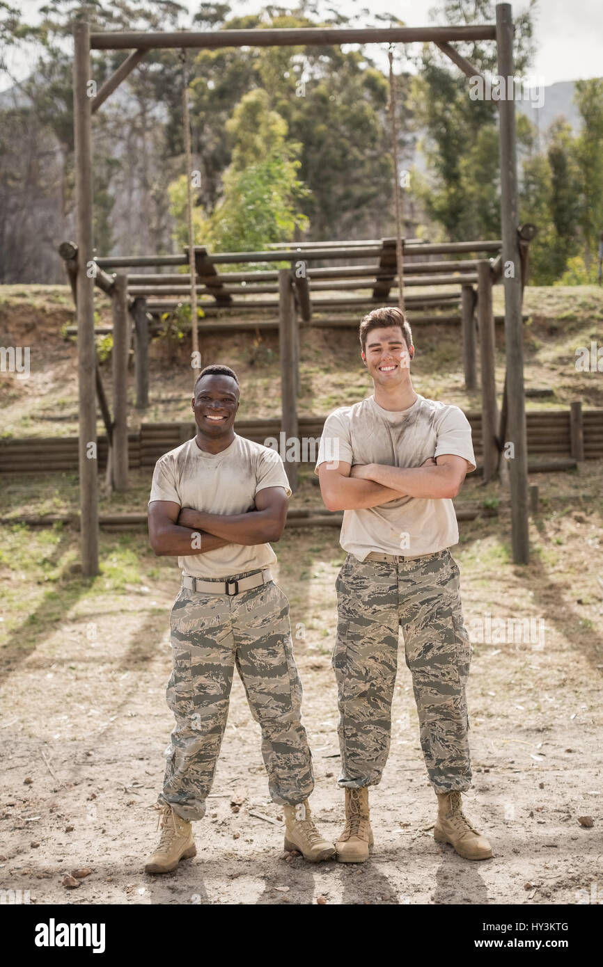 Portrait of military man standing with arms crossed during obstacle ...