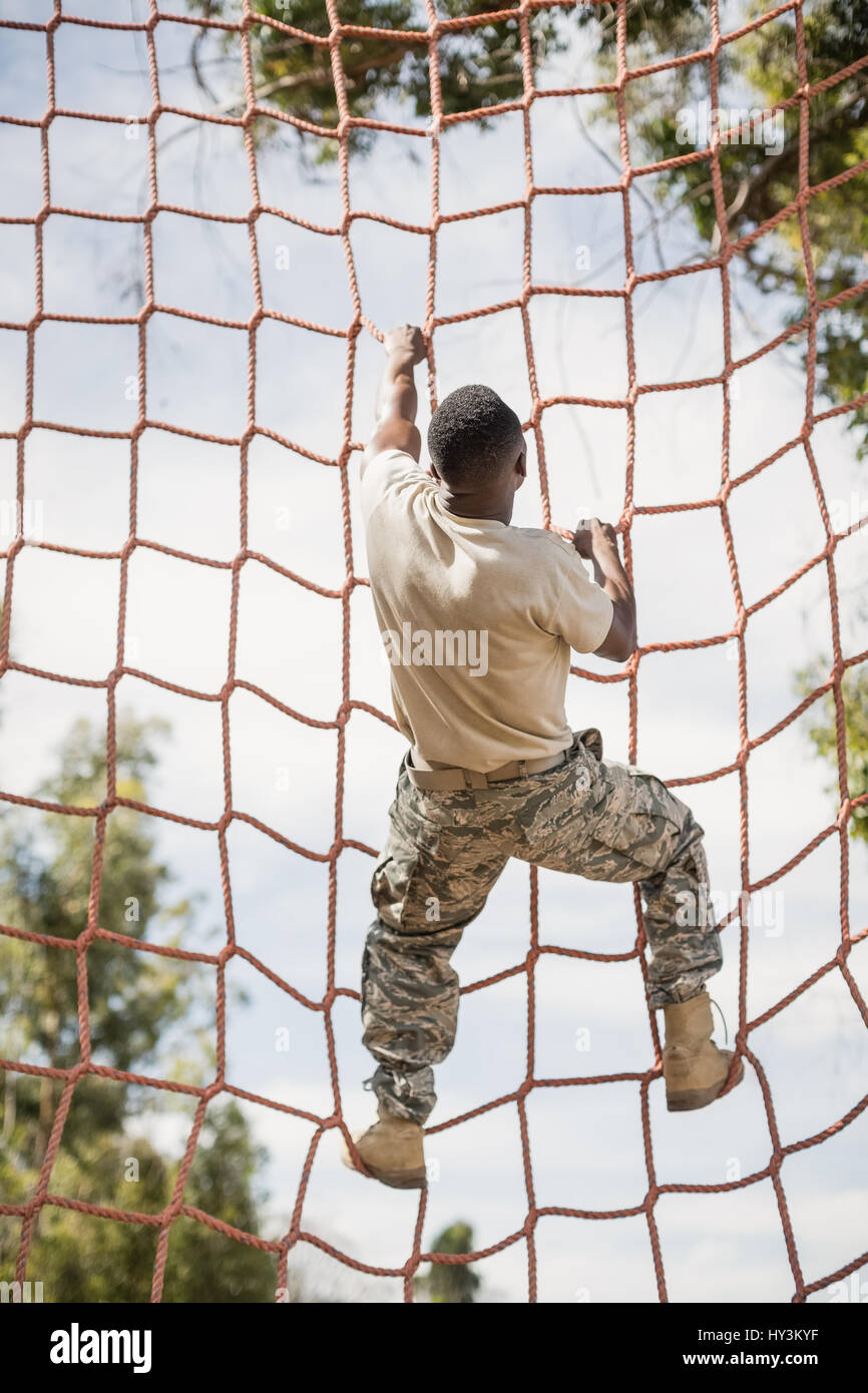 Military soldier climbing net during obstacle course in boot camp Stock ...